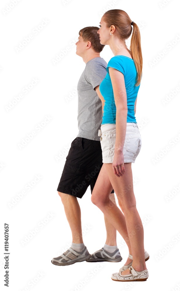 Back view of going young couple (man and woman). walking beautiful ...