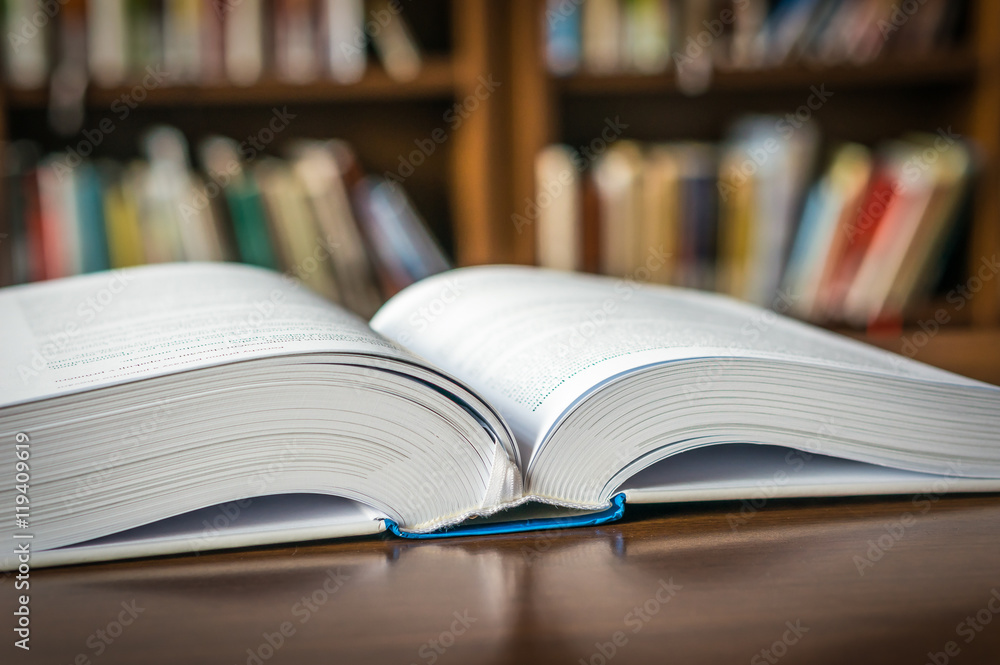Open book on the table in a library and bookshelf Stock Photo | Adobe Stock