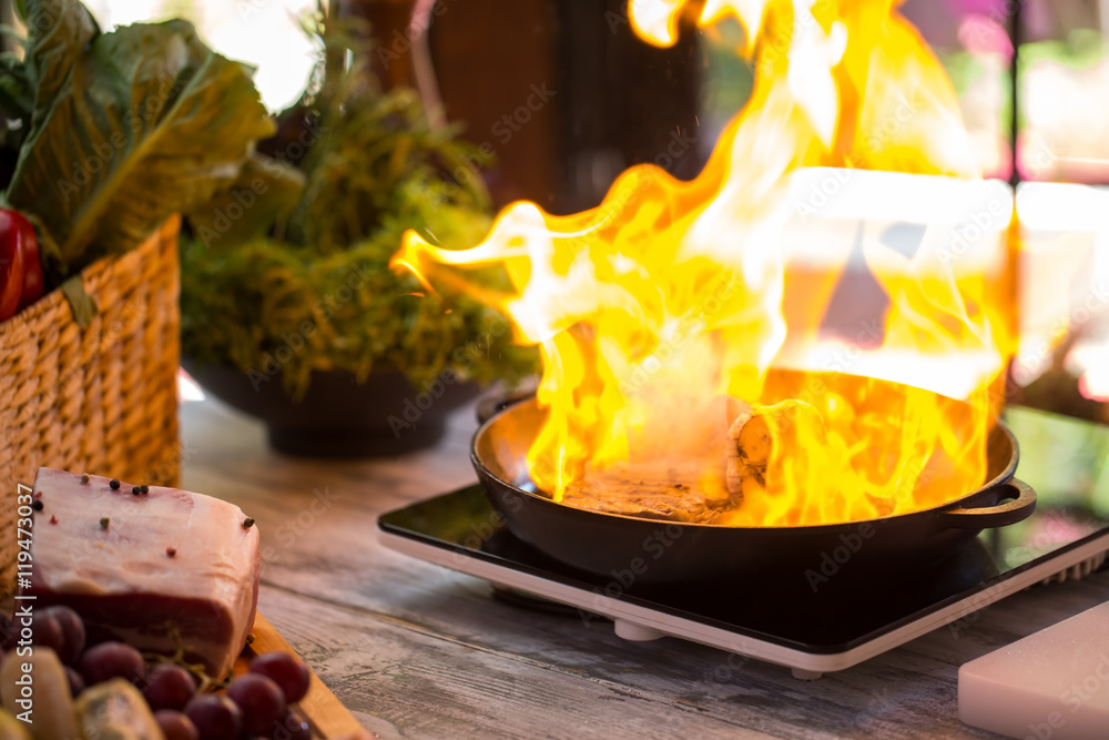 Flame in a pan. Meat and yellow fire. Special methodology of cooking ...