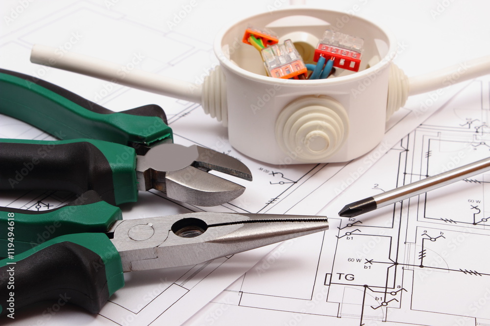 Work tools and electrical box with cables on construction drawing of ...