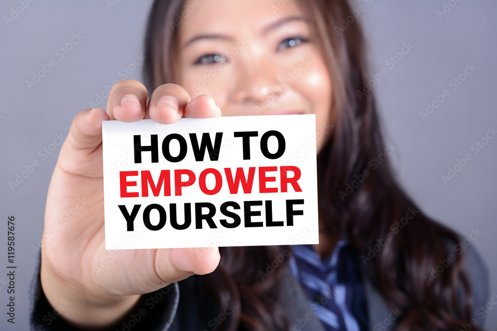 HOW TO EMPOWER YOURSELF message on the card shown by a businesswoman ...