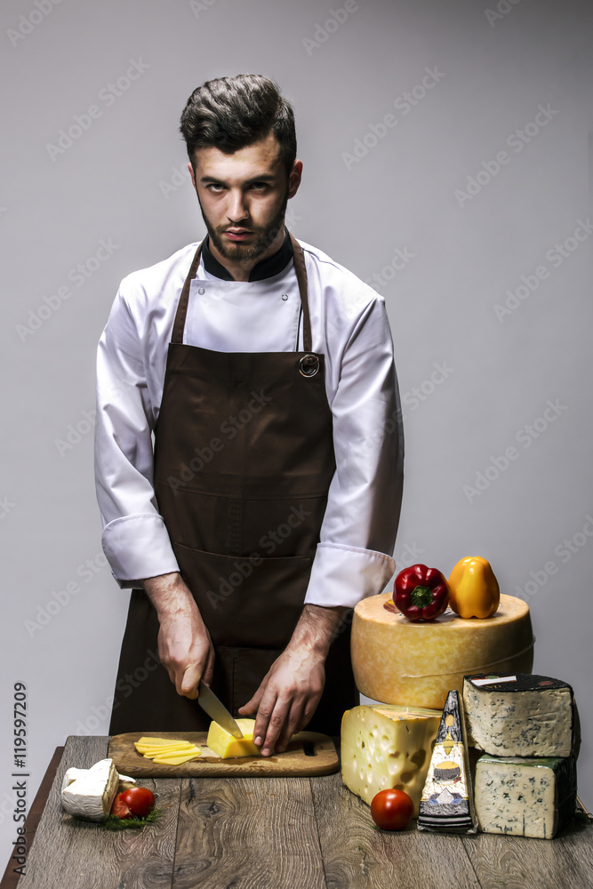 blur or defocus image of young chef cuts the cheese on the table ...