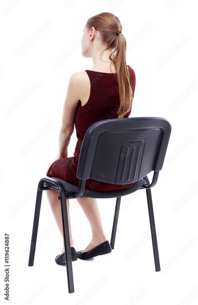 back view of young beautiful woman sitting on chair. Isolated over ...