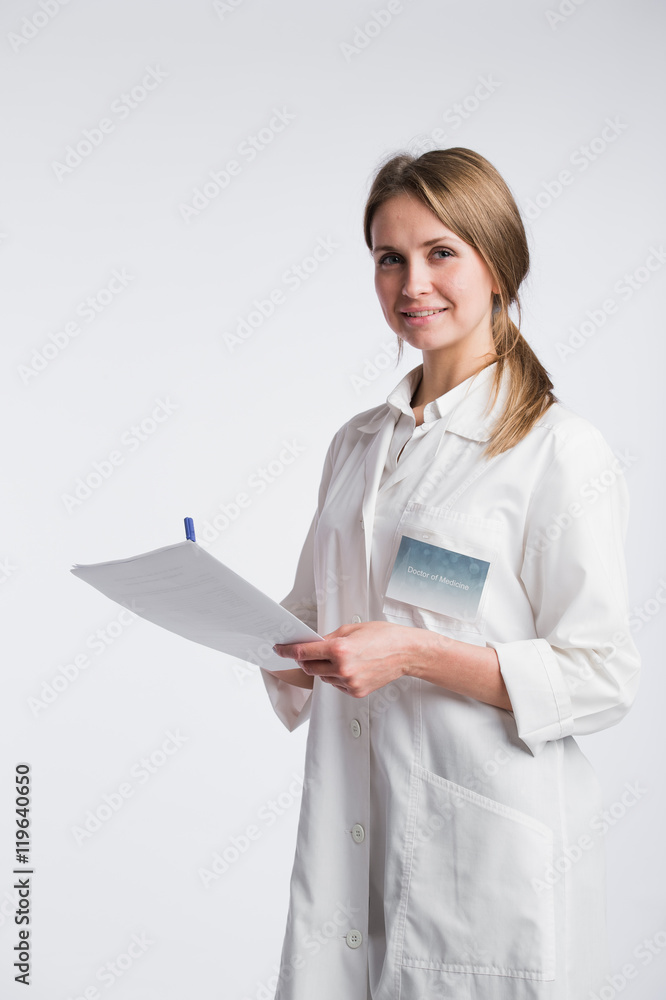 Beautiful nurse smiling and taking notes on a white isolated background ...