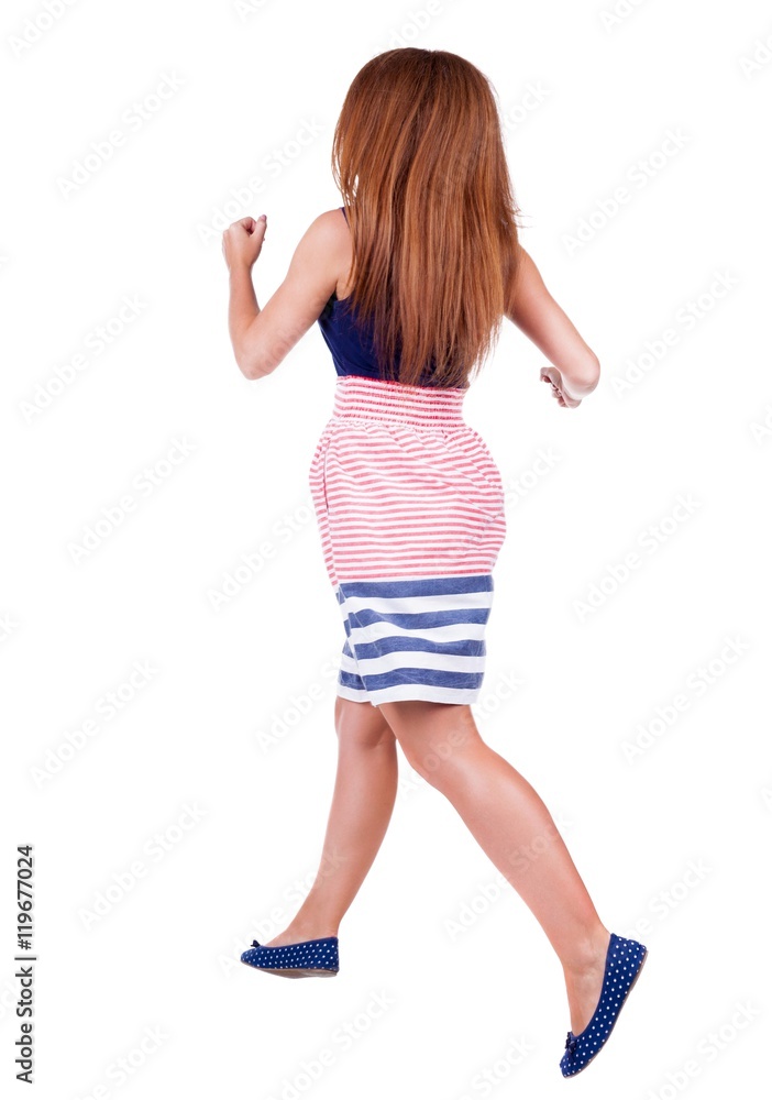 back view of running woman. beautiful red head girl in motion. backside ...