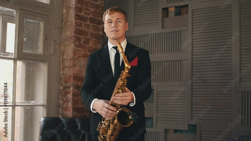 Saxophonist in dinner jacket dance with golden saxophone at stage. Jazz ...