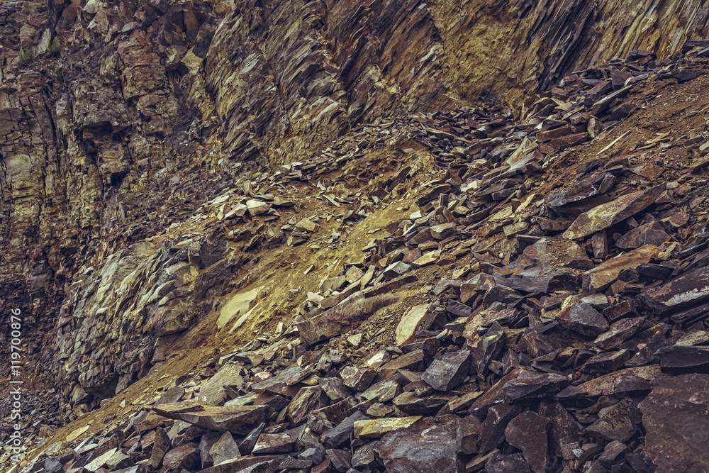Poster Arid strata volcanic stone cliff and rock debris in an old ...