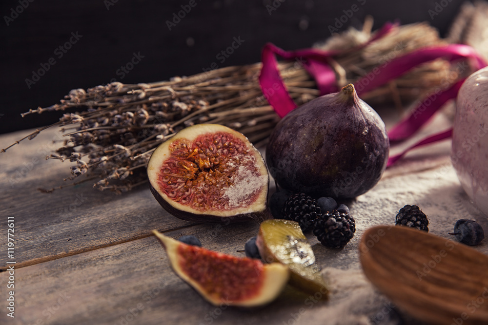 Whole figs and one fig sliced in half on top of a teak garden ta Stock ...