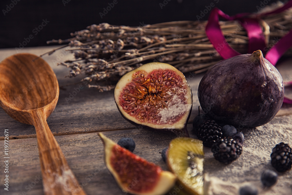 Whole figs and one fig sliced in half on top of a teak garden ta Stock ...