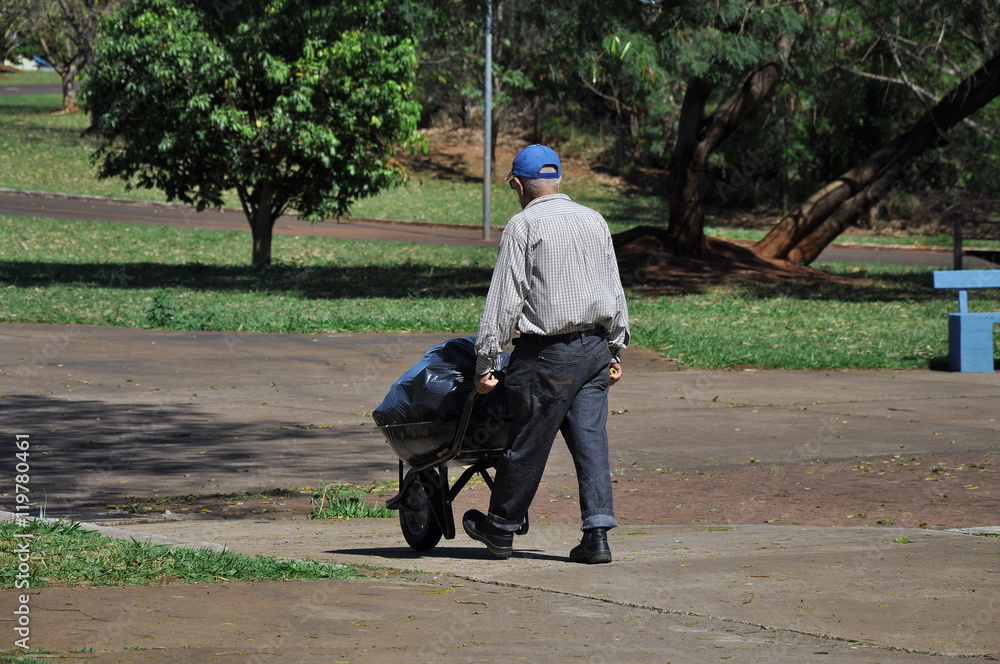 Old man taking out the trash in a wheelbarrow Stock Photo | Adobe Stock