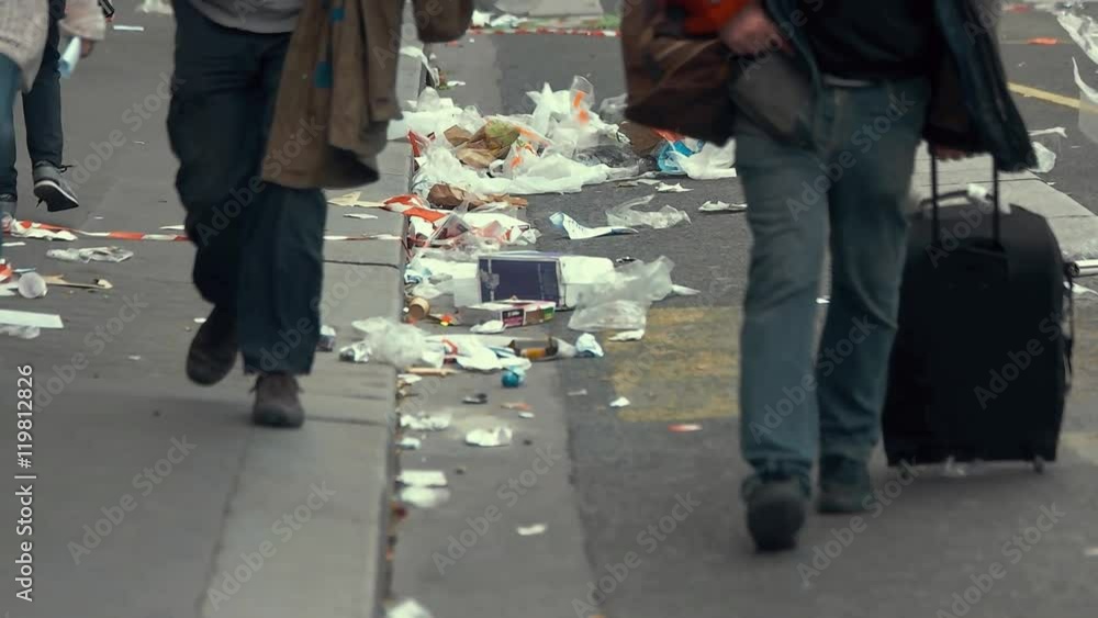 People walking past garbage. Trash on city road. Danger under our feet ...