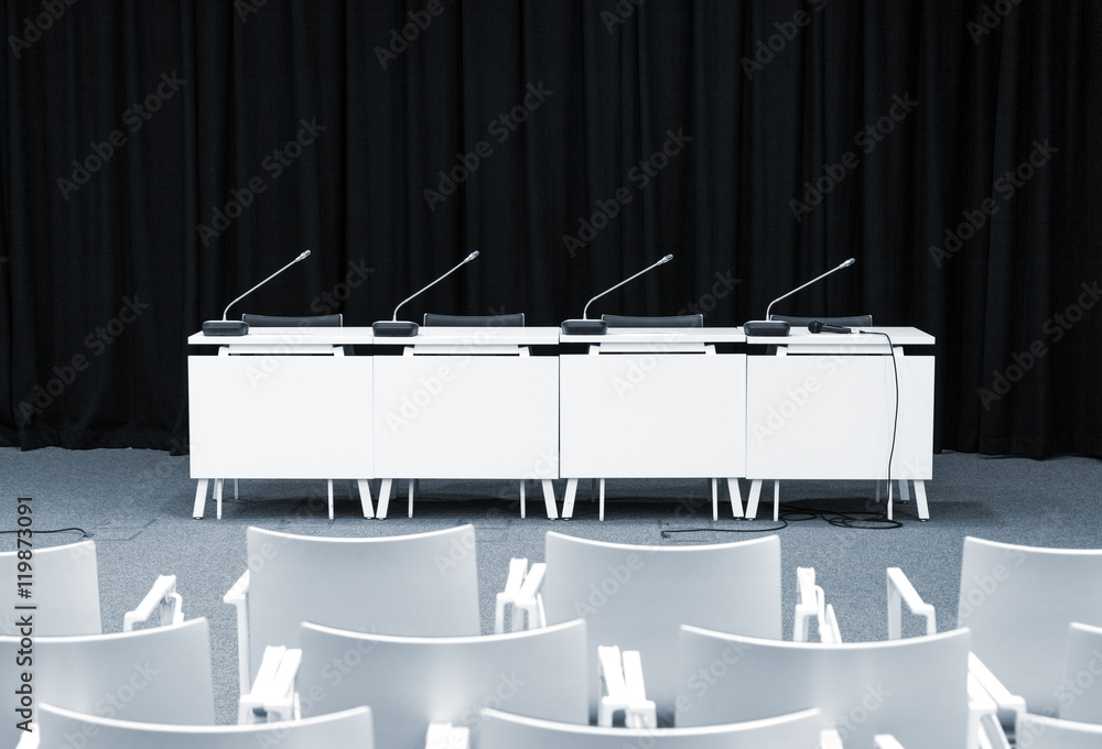 Monochrome picture of empty press conference room with seats, stand ...