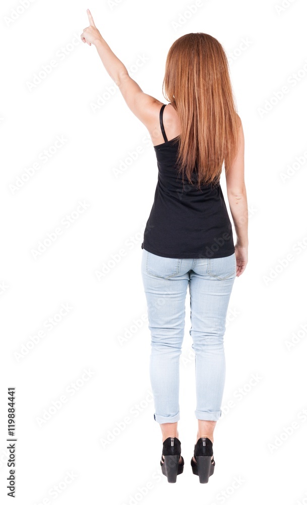 Back view of pointing woman. beautiful redhead girl in jeans. Rear view ...