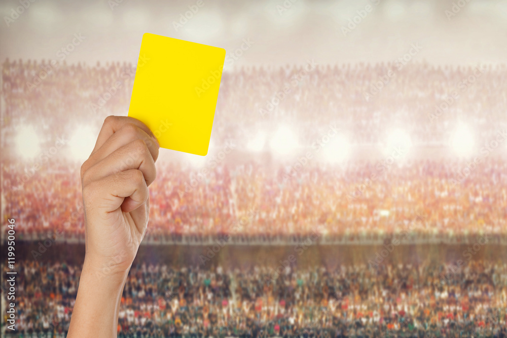 Hand holding up yellow card in football stadium during match Stock ...