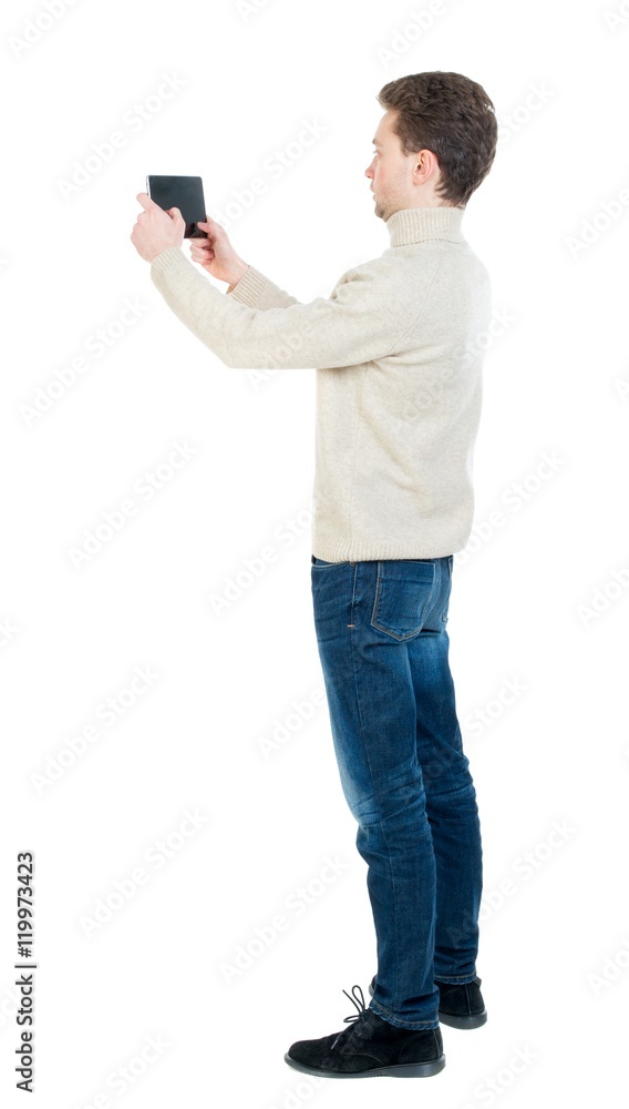 back view of standing business man photographing a phone or tablet ...