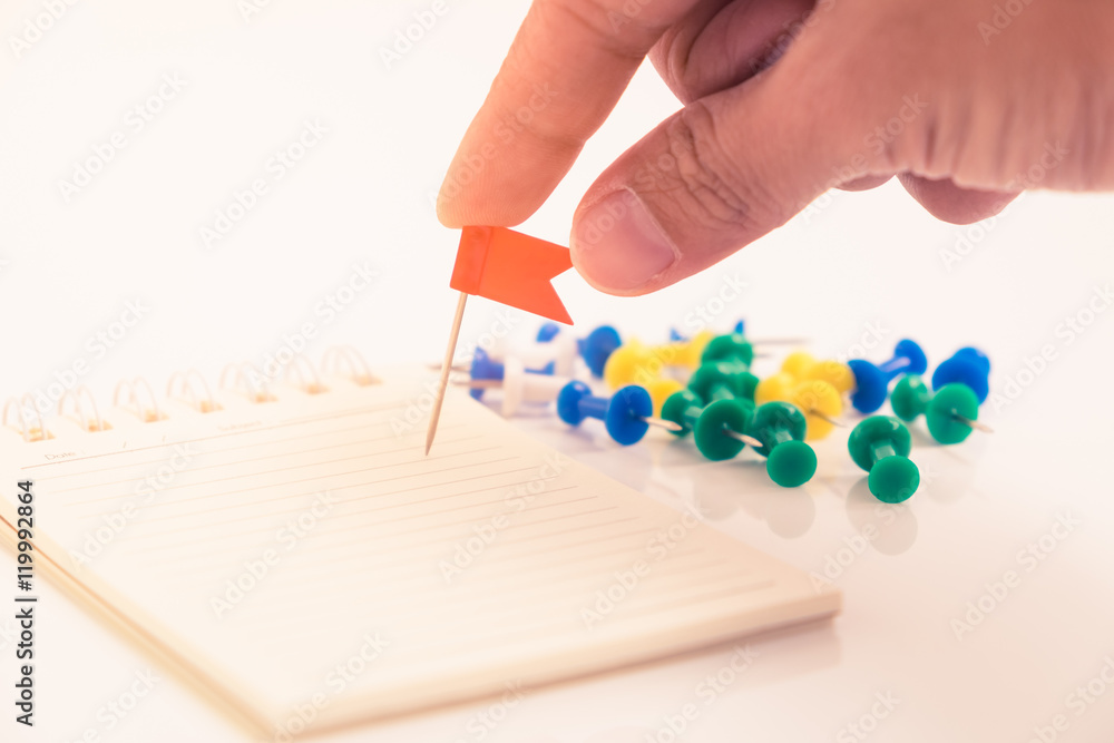 Red flag pin hold by woman hand pinned on white paper notebook foto de ...