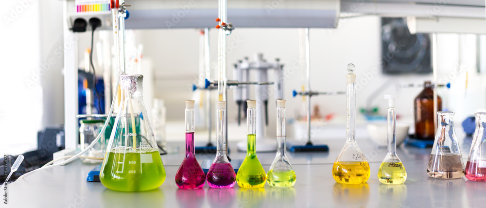 Laboratory table piled tubes with colored liquid, colored reagents in ...