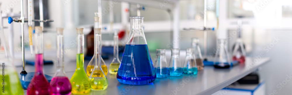 Laboratory table piled tubes with colored liquid, colored reagents in ...