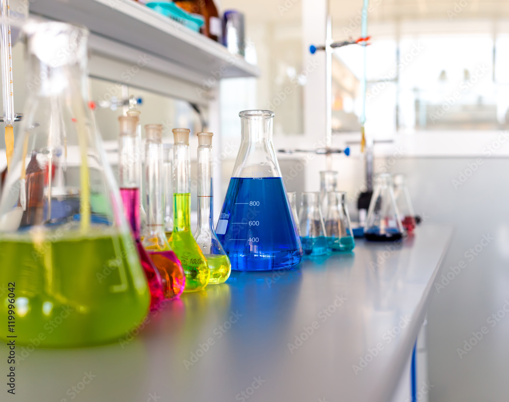 Laboratory table piled tubes with colored liquid, colored reagents in ...