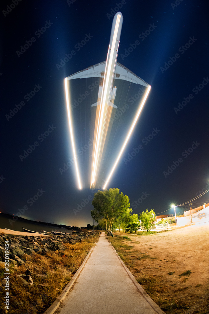 Jet plane with lights trails landing Stock Photo | Adobe Stock
