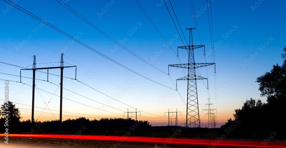 Pylons and electricity power lines at night with traffic lights Stock ...