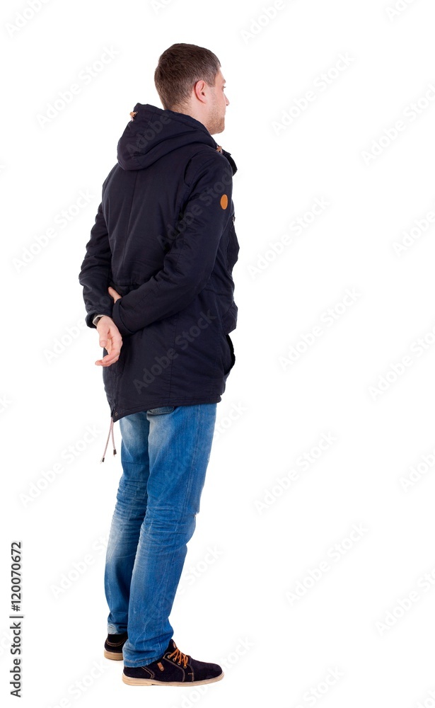 Back view of handsome man in winter jacket looking up. Standing young ...