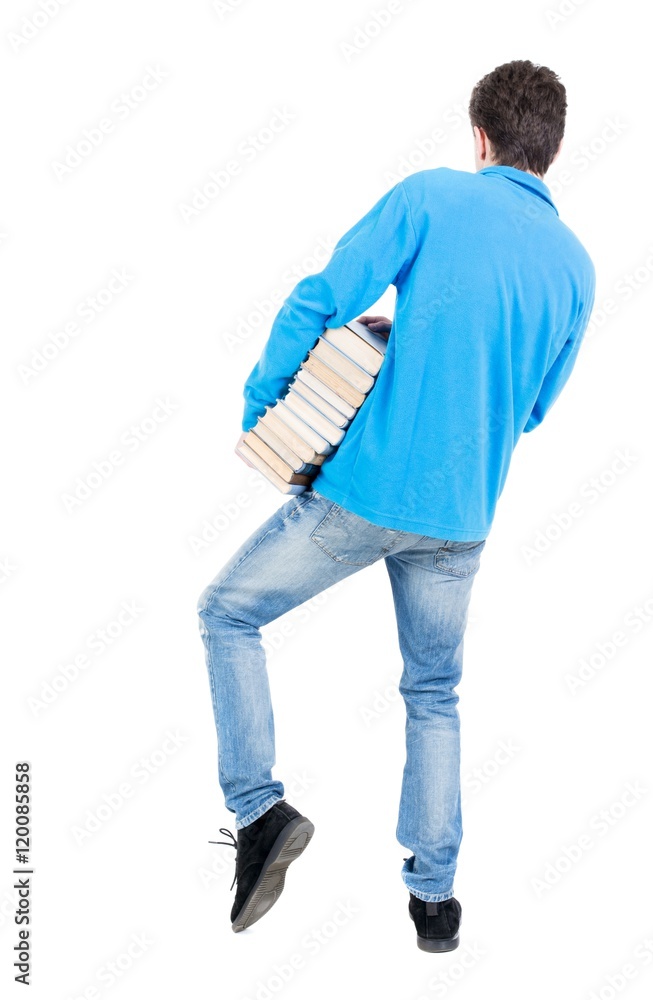 A man carries a heavy pile of books. back view. Rear view people ...
