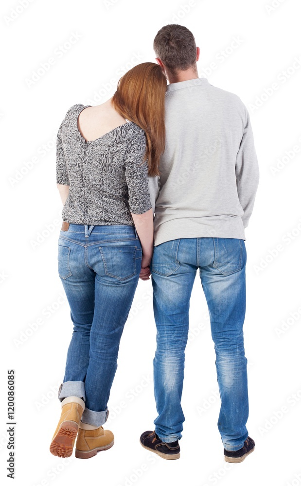 Back view of young embracing couple (man and woman) hug and look into ...