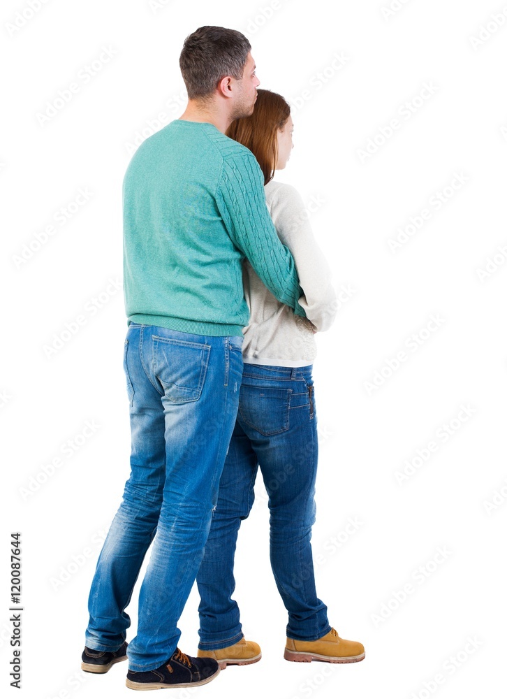 Back view of young embracing couple (man and woman) hug and look into ...