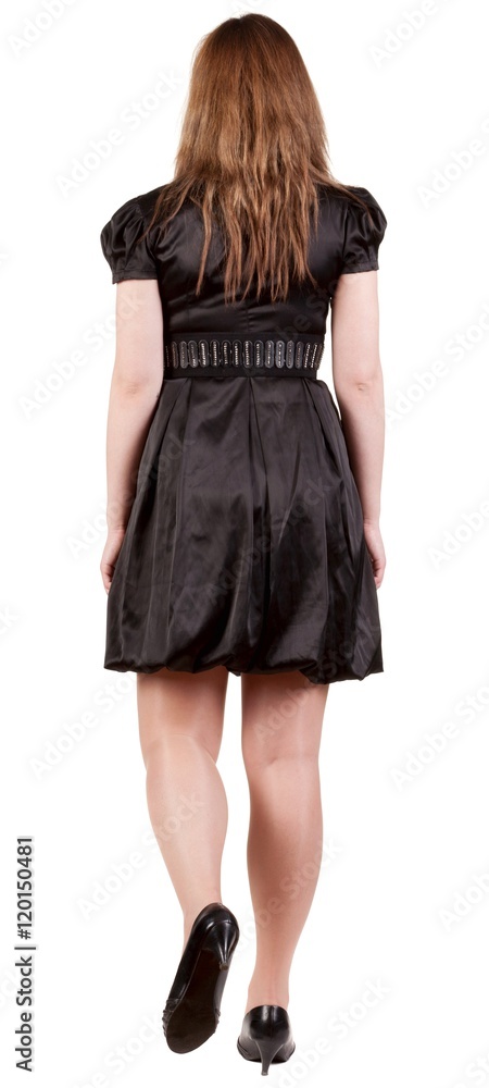 back view of going brunette woman in black dress. beautiful girl in ...