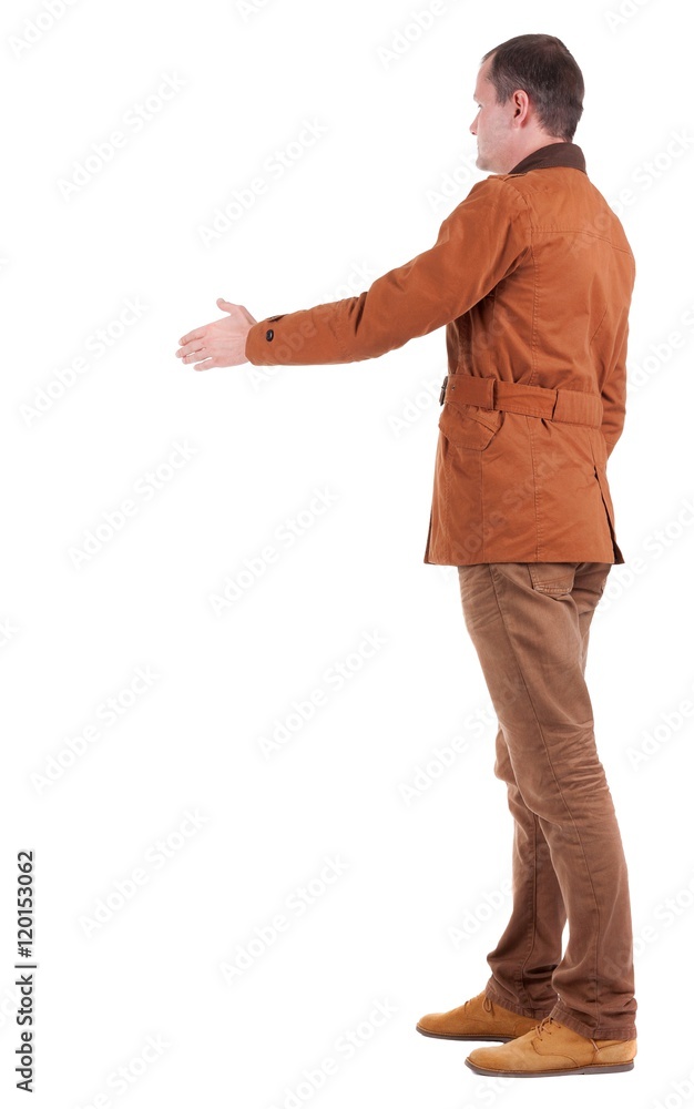 back view of businessman in movement reaches out to shake hands. Rear ...