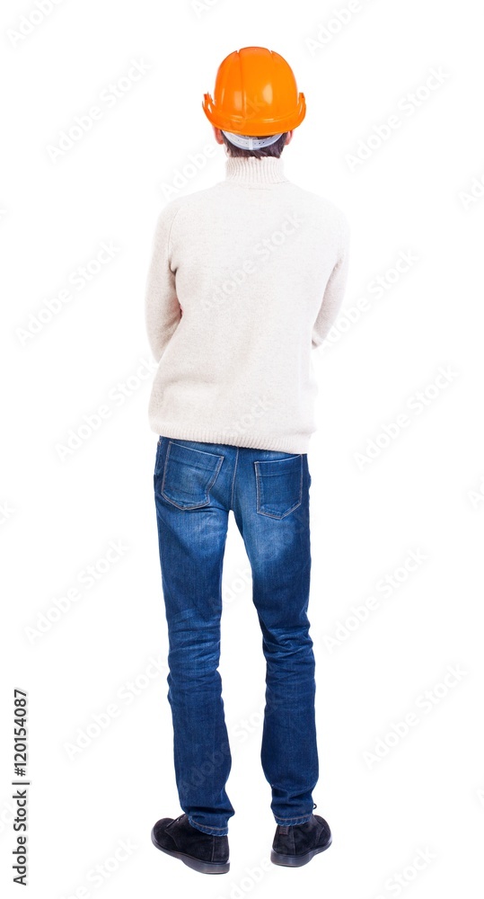 Backview of an engineer in construction helmet stands. Standing young ...