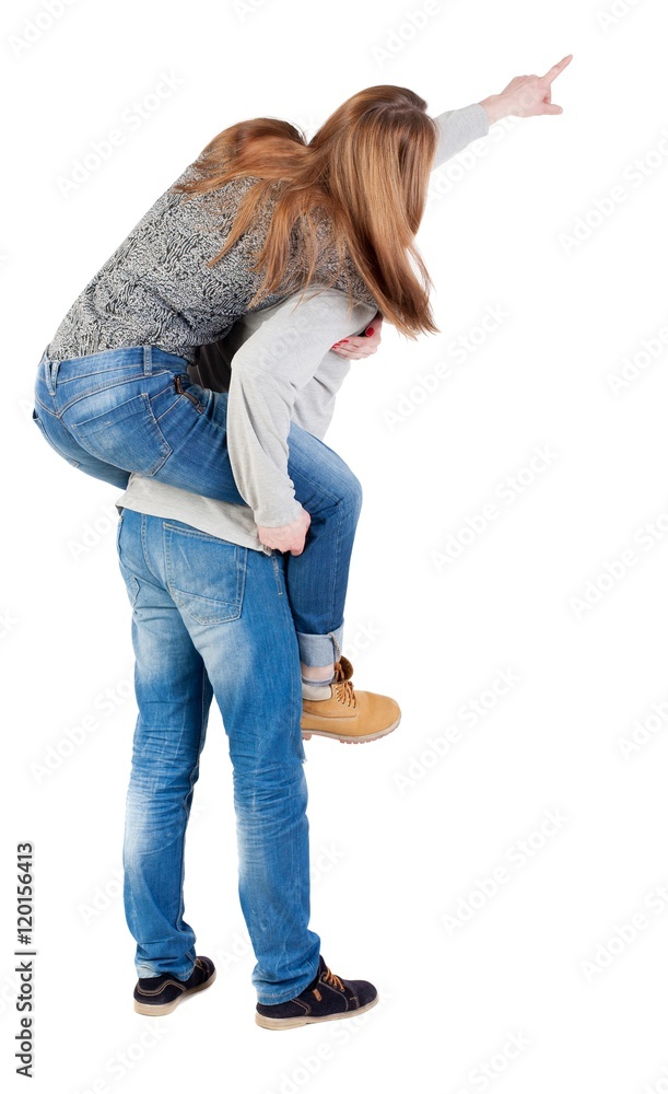 young couple pointing at wal Back view (woman and man). Rear view ...