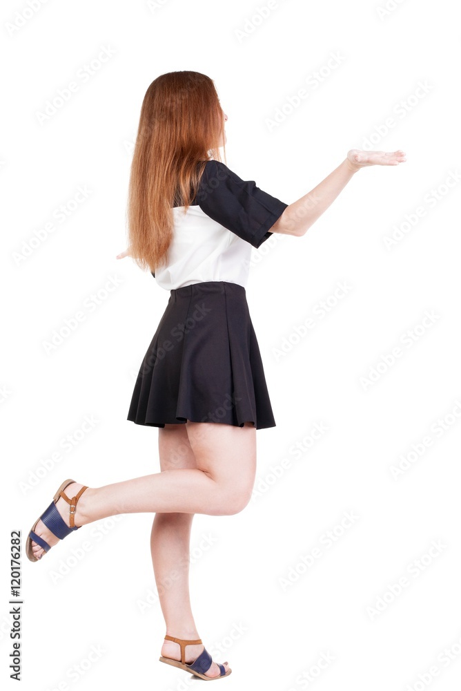 Back view of Beautiful woman in dress looking at wall and Holds hand up ...