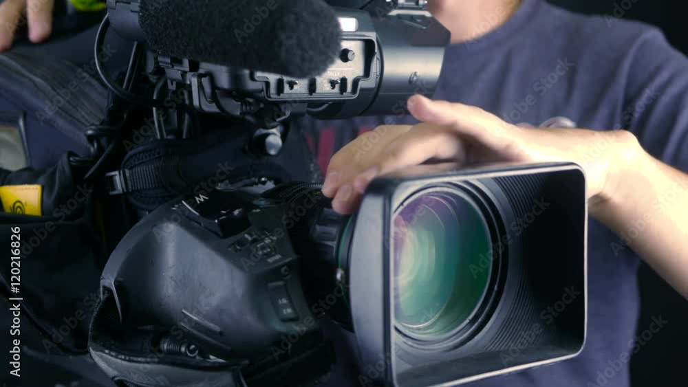 Studio camera. Cameraman changing camera settings focal length ...