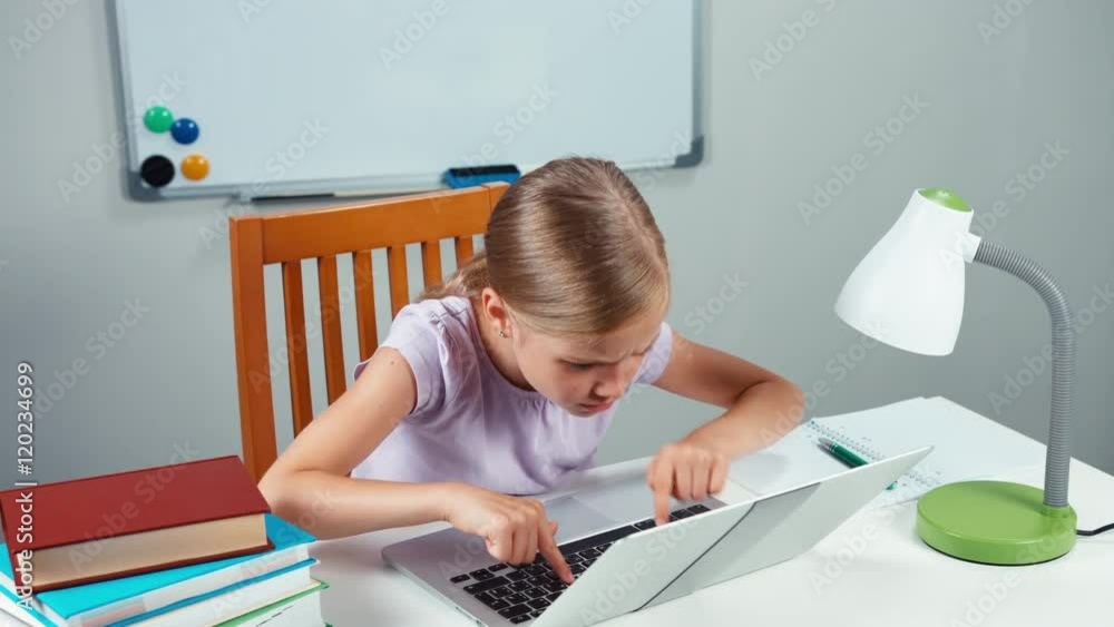 Portrait angry child girl 7-8 years something typing on laptop sitting ...
