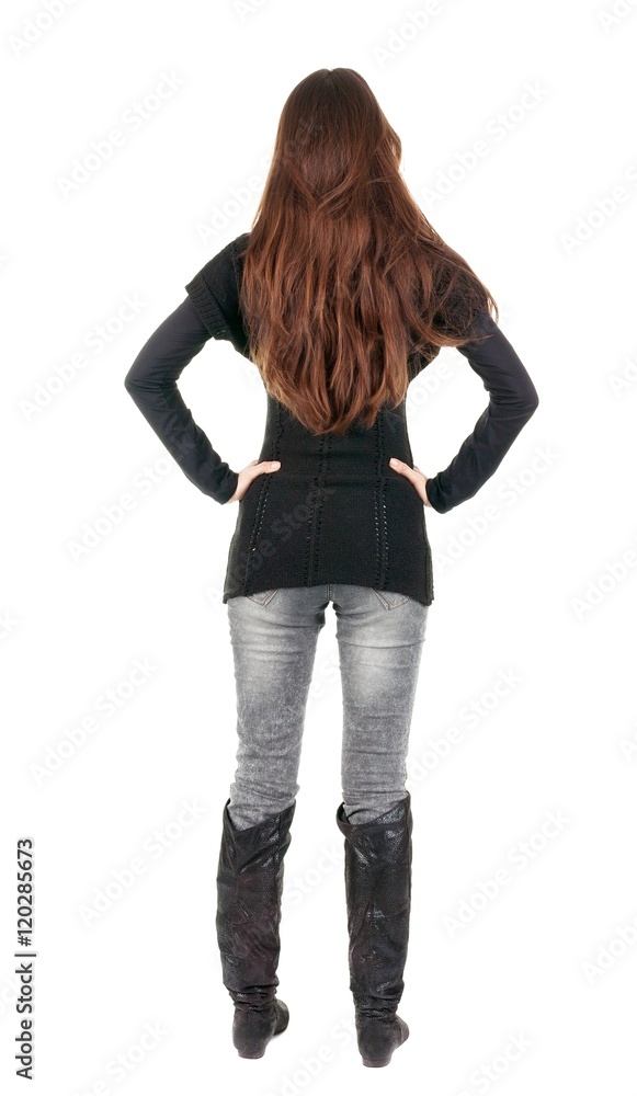 back view of standing young beautiful woman. blonde girl in jeans and ...