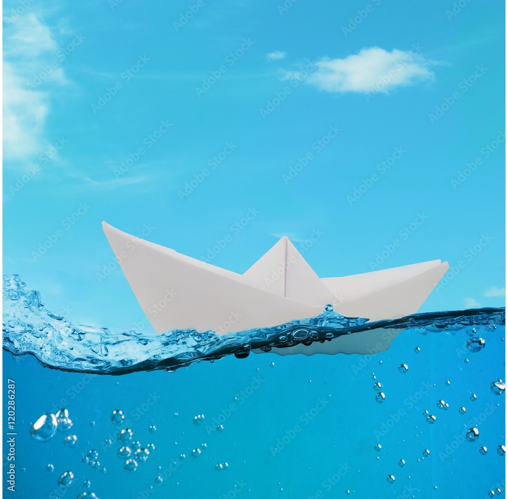 paper boat floating among the waves in the ocean. origami boat floating ...