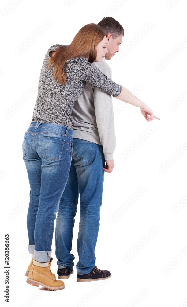young couple pointing at wal Back view (woman and man). Rear view ...