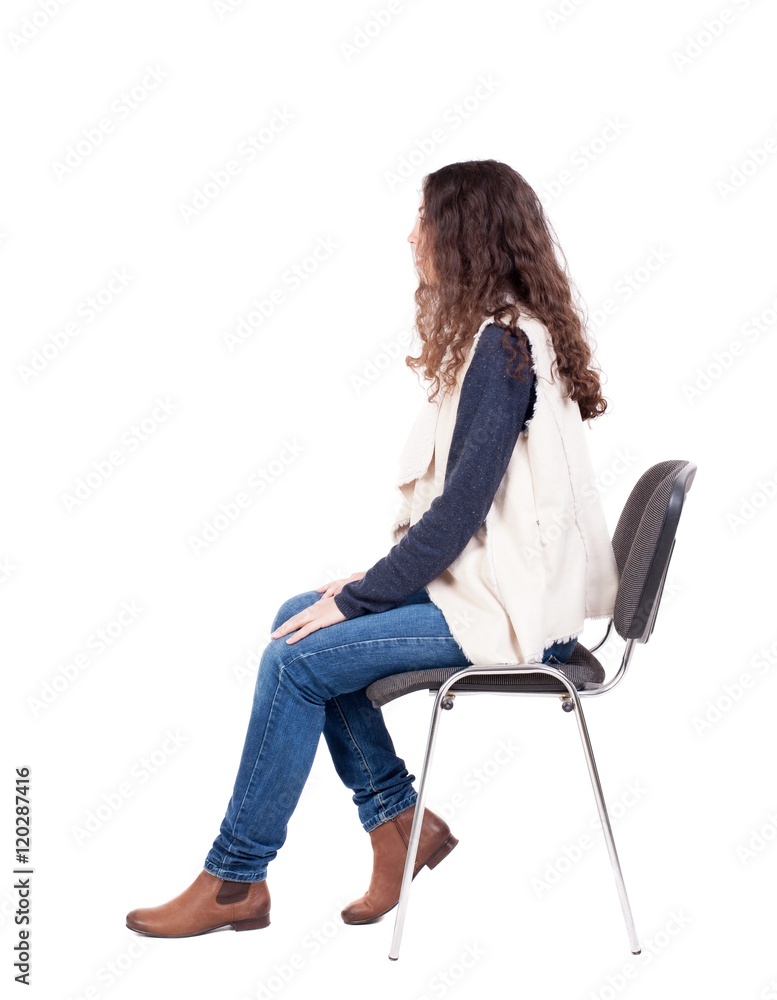 back view of young beautiful woman sitting on chair. girl watching ...