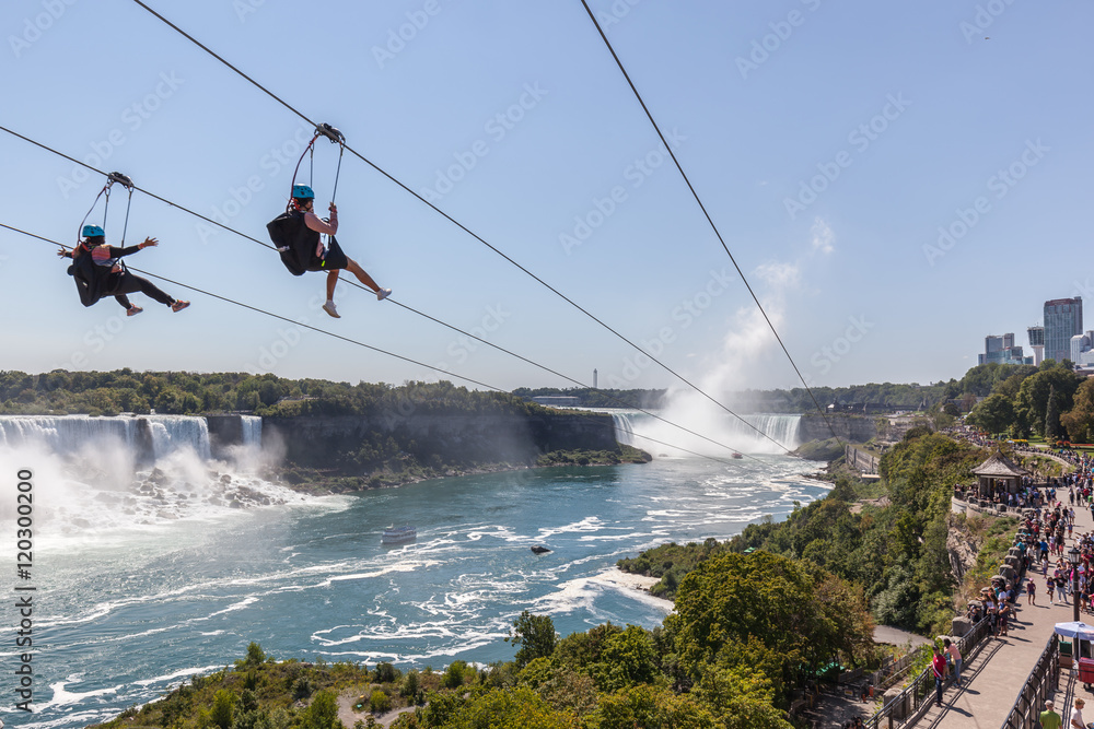 Two Unrecognisable people taking zipline ride at Niagara Falls, Ontario ...