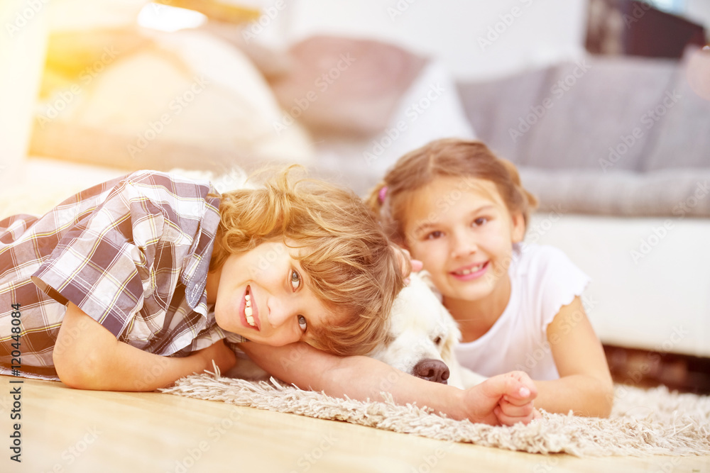 Zwei Kinder spielen mit dem Hund zu Hause Stock Photo | Adobe Stock