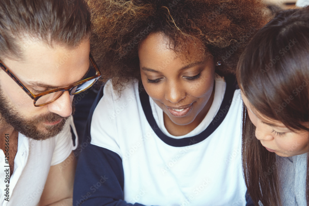 Teamwork and cooperation. Three young entrepreneurs working together at ...