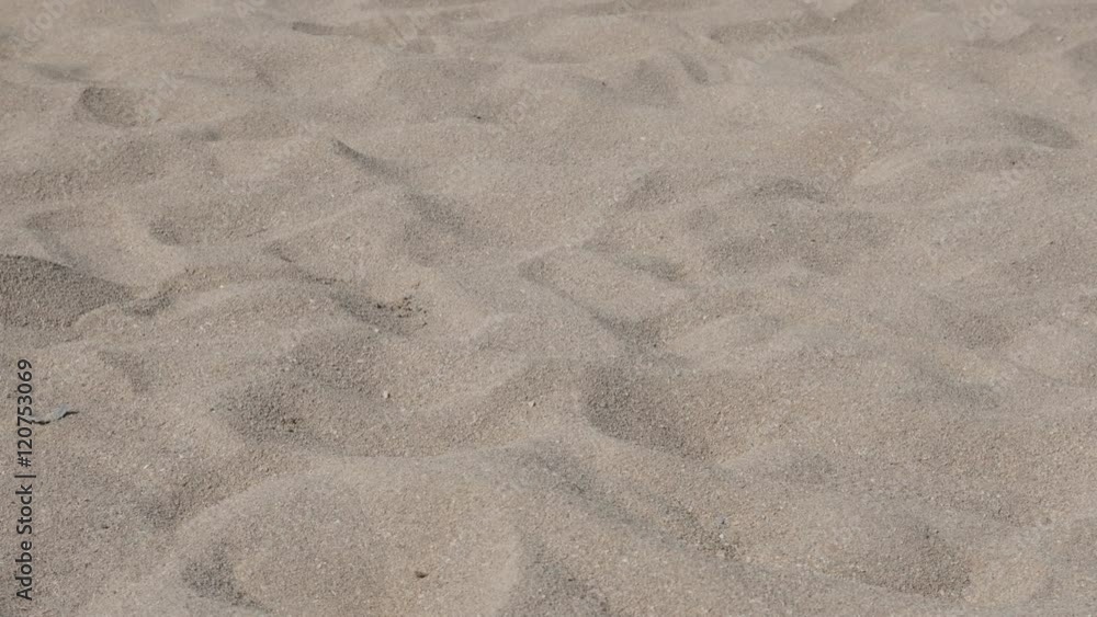 White beach fine sea sand granulation with foot stamps and tire trails ...
