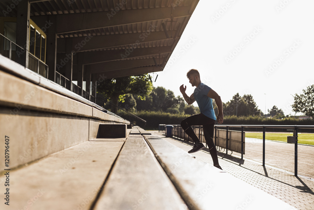 Athlete exercising on grandstand of a track and field stadium Stock ...