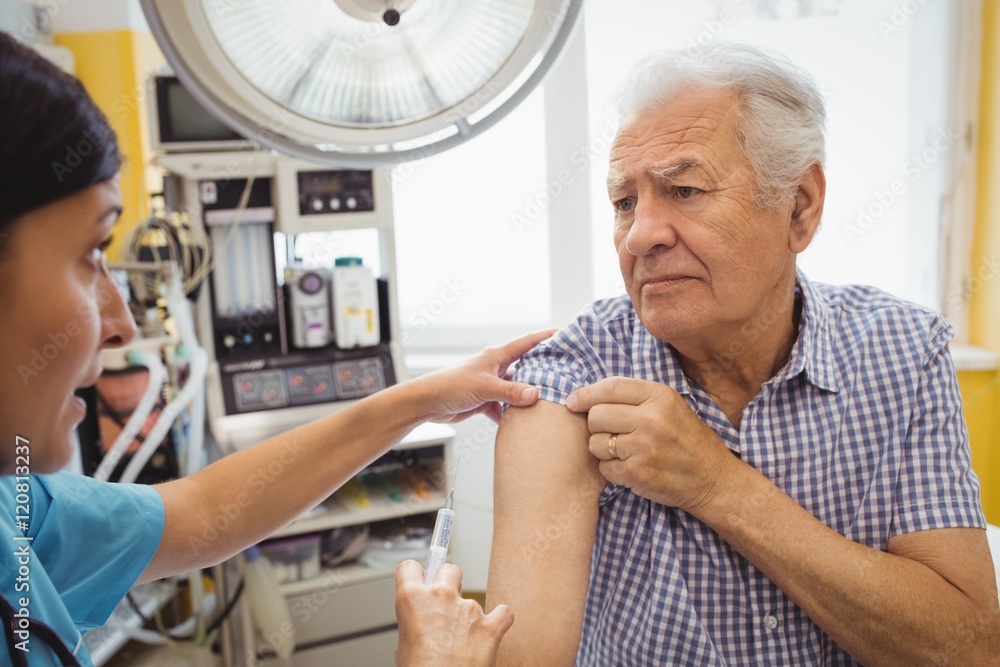 Female doctor giving an injection to a patient Stock Photo | Adobe Stock