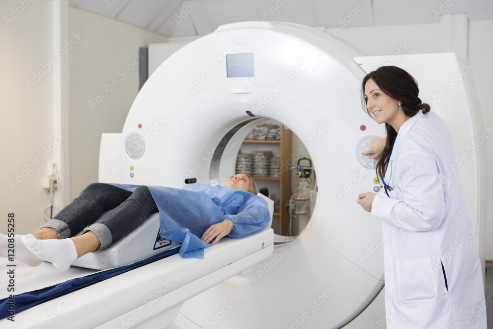 Patient Lying On MRI Machine While Female Doctor Operating It Stock ...