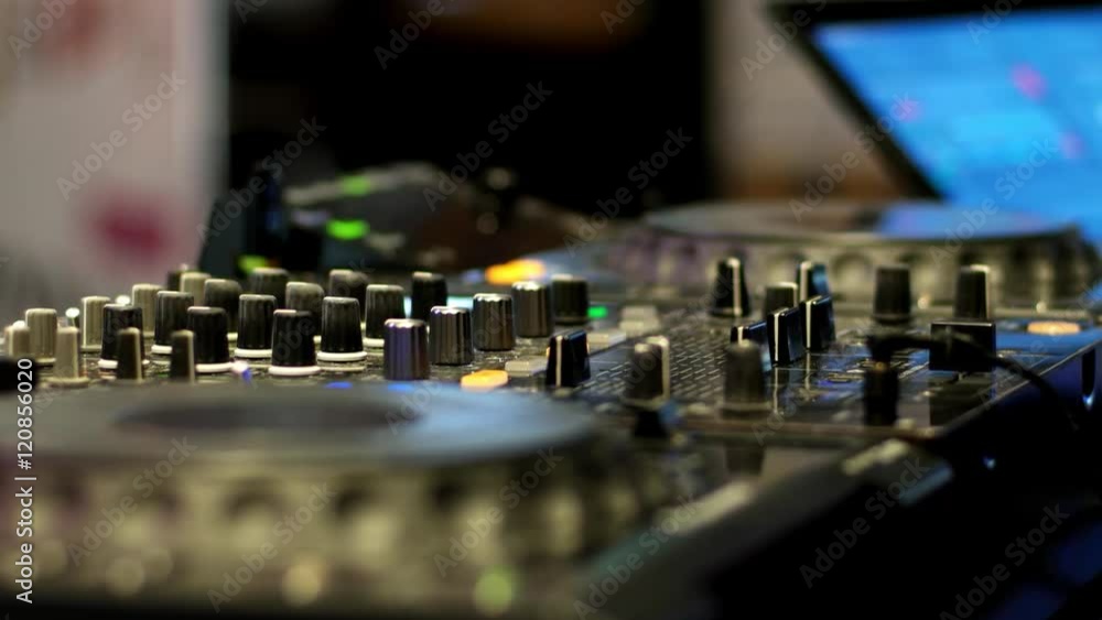 DJ at work in a nightclub musician hand operated DJ-controller, remote ...
