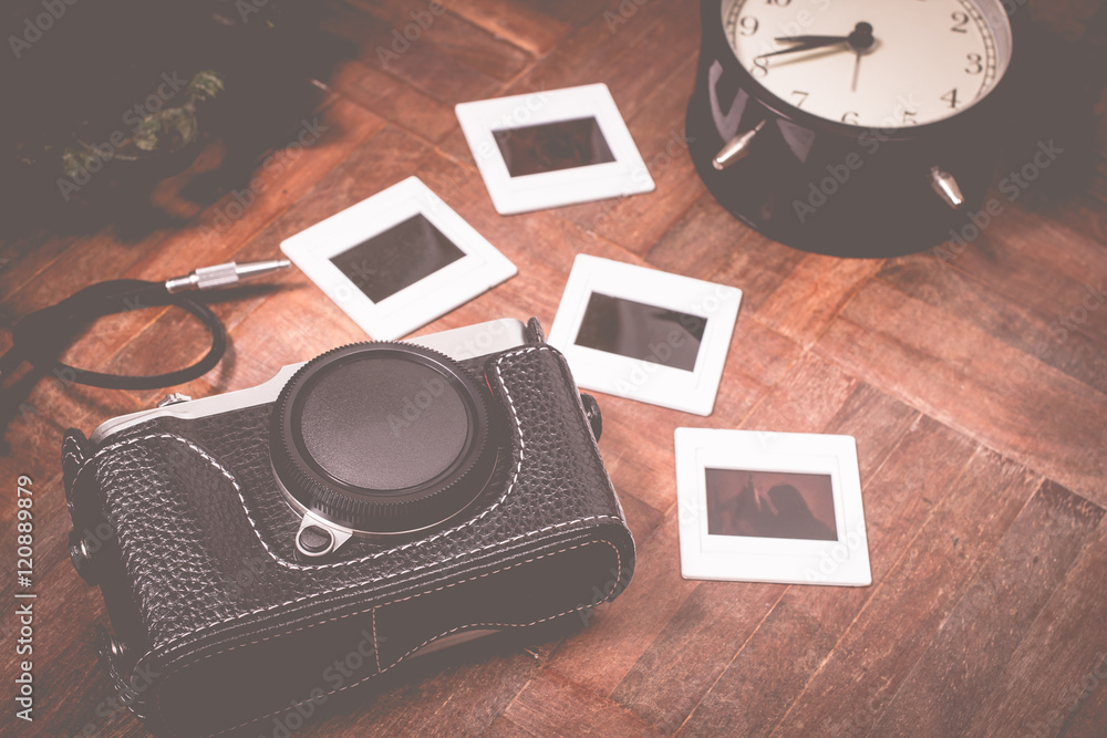 old & classic rangefinder camera, slide film and vintage clock on ...