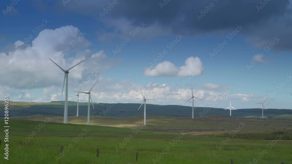 Giant windmills on the big field with propellers turning around on one ...